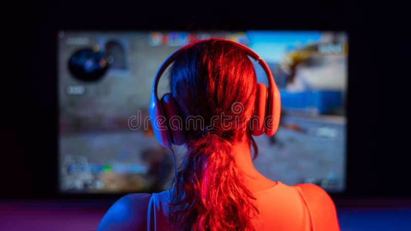 Rear View of a Caucasian Woman Playing a Computer Game in Neon Light in ...
