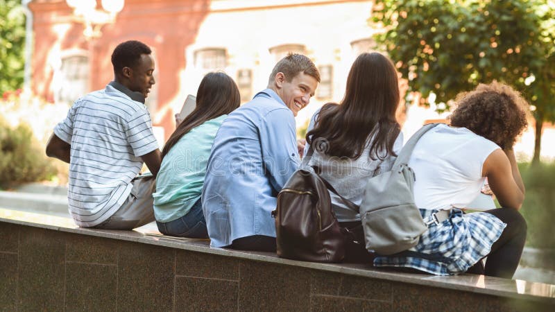 Rear View of Cheerful College Students Relaxing Outdoors after Classes ...