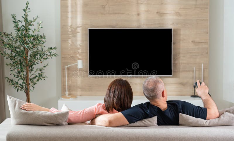 Rear View Couple Lying on Sofa in Living Room Stock Photo - Image of ...
