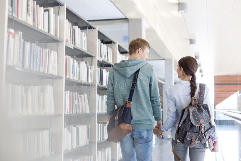 Rear View of Couple Walking while Holding Hands in Library Stock Image ...