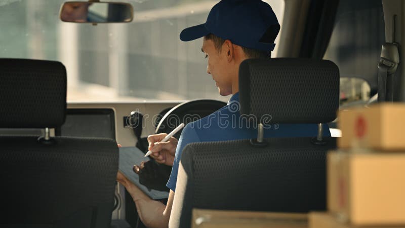 Rear View of Courier Using Digital Tablet Tablet in Van Full of ...
