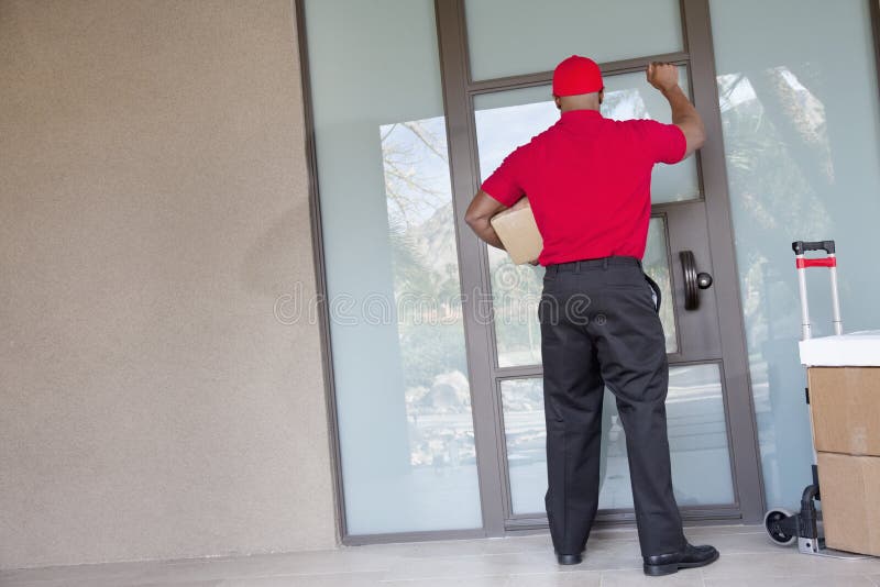 Rear View of a Delivery Man with Packages Knocking at Door Stock Photo ...
