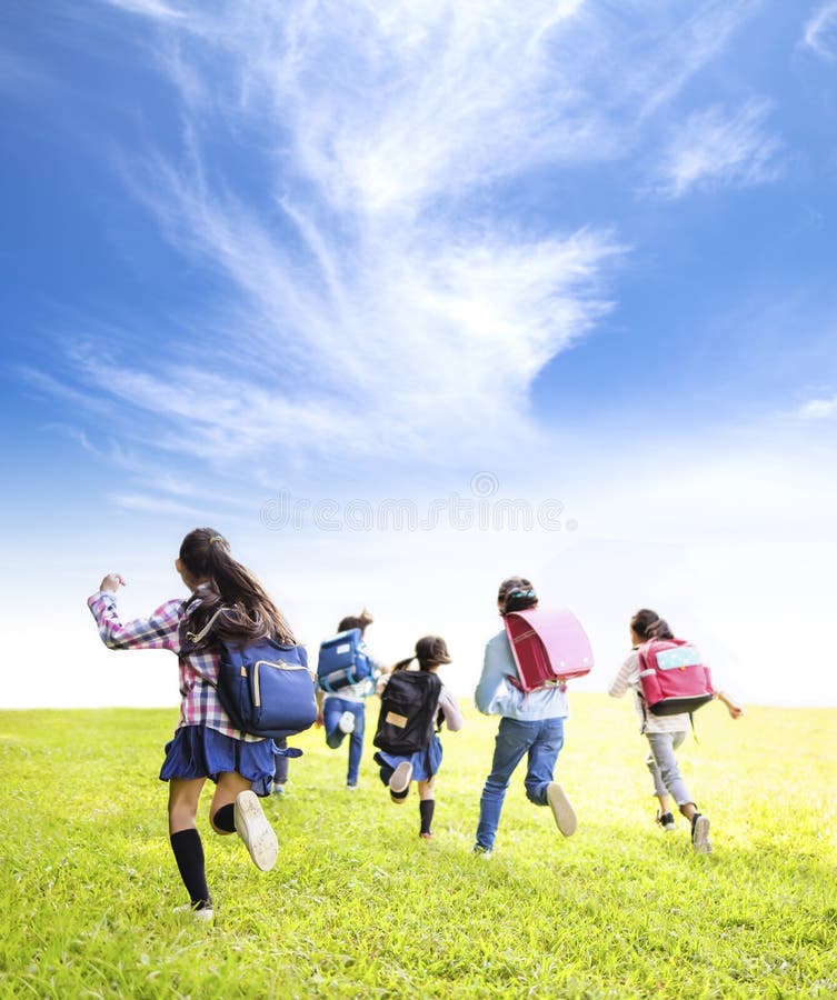 Rear View of Elementary School Kids Running on the Grass Stock Image ...