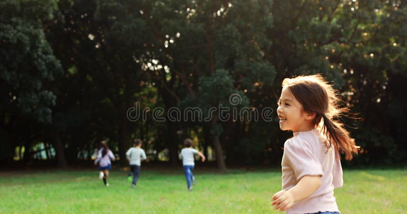 Rear View of Elementary School Kids Running on the Grass Stock Footage ...