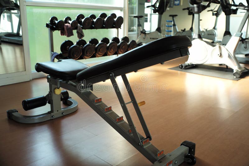Rear View of Exercise Bench with Blurred Racks of Dumbbells in ...