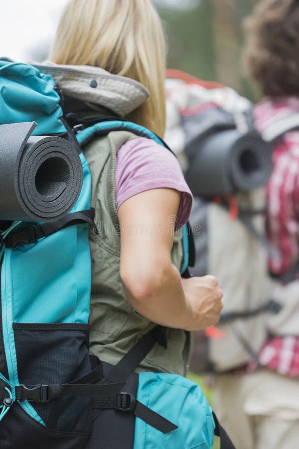 Rear View of Female Hiker Carrying Backpack with Man in Background ...