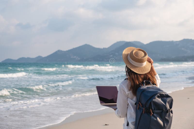 A Female Traveler Using and Working on Laptop Computer while Walking on ...