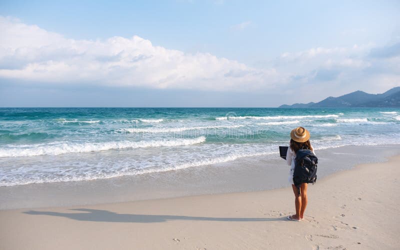 A Female Traveler Using and Working on Laptop Computer while Walking on ...