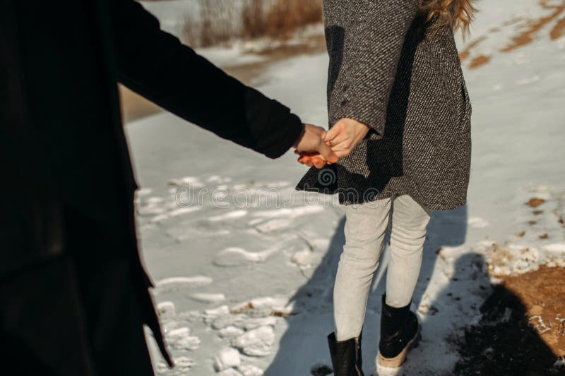 Rear View of a Girl and a Guy, the Girl Leads the Guy Forward by the ...
