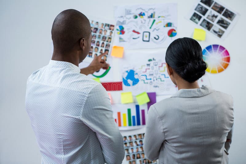 Rear View of Graphic Designers Discussing Over Charts and Graph Stock ...