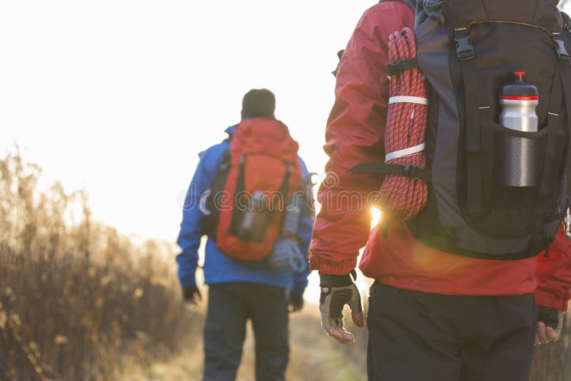 Rear View of Male Backpackers Walking in Field Stock Photo - Image of ...