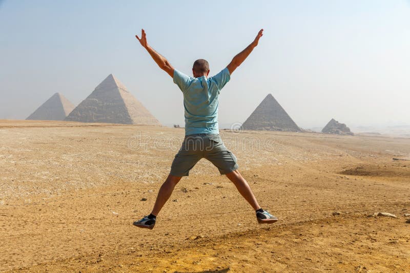 Rear View of a Man Jumping Against the Famous Pyramids of Giza in Egypt ...