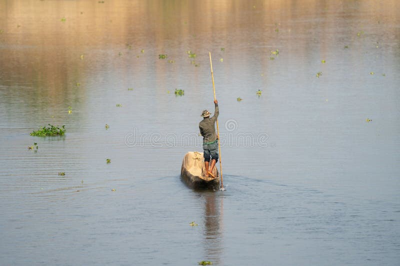 Rear View of a Man Rowing a Boat on a Tranquil Lake with a Pole Stock ...