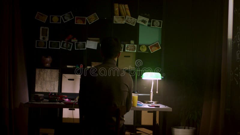 Man Sitting in Dim Room with Soft Light Behind, Looking Thoughtful ...