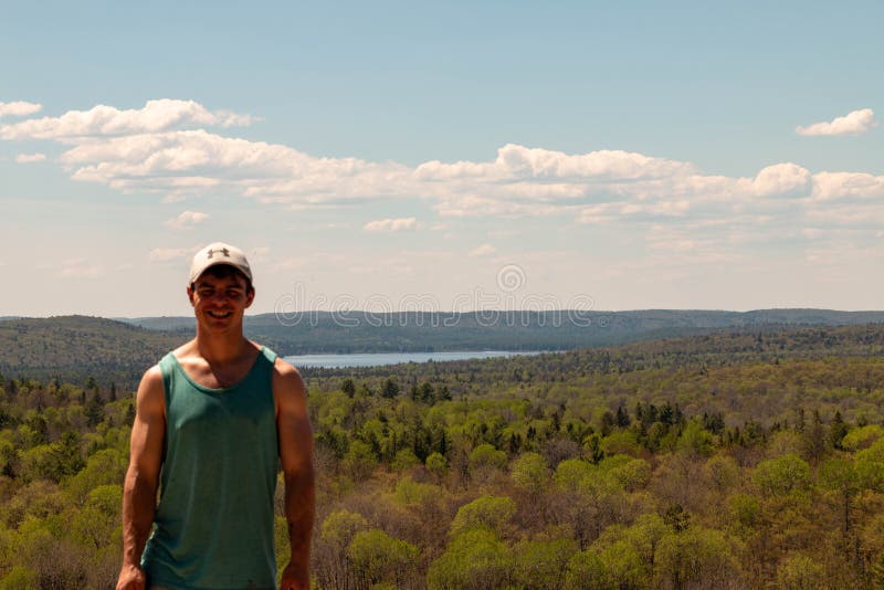 Rear View of Man Sitting on Rock Over Landscape. Stock Image - Image of ...