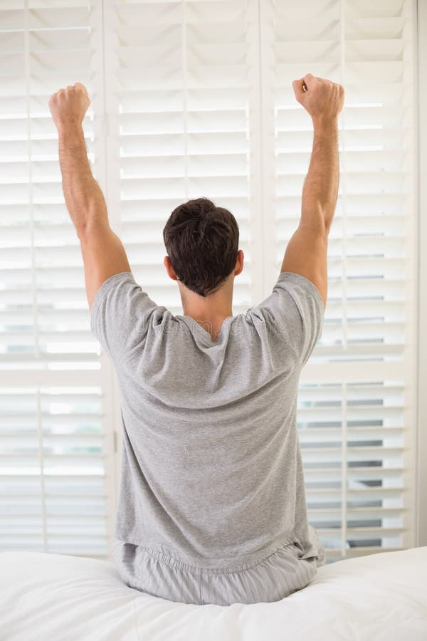 Rear View of Man Stretching His Arms in Bed Stock Image - Image of rear ...