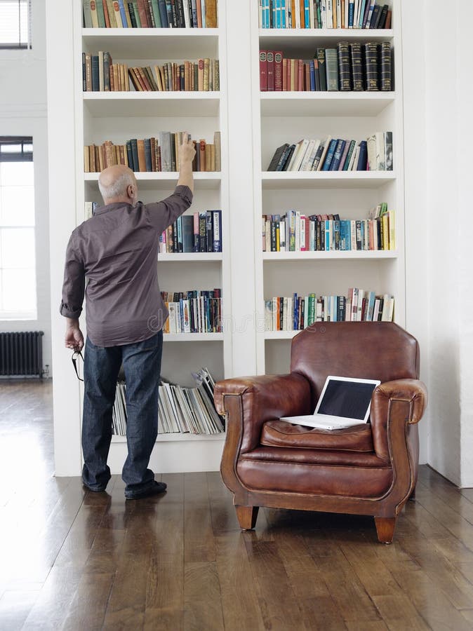 Man Choosing Book from a Shelf Stock Image - Image of looking, holding ...