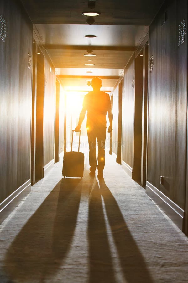 Rear View of Man Walking with His Suit Case in Hotel Stock Photo ...