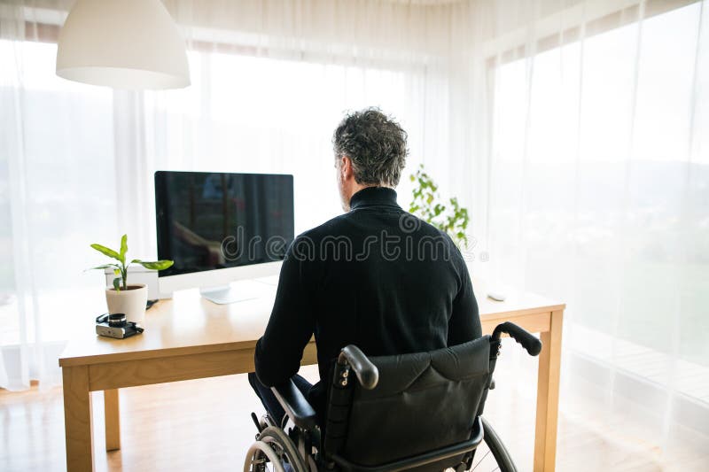 Rear View of Man in Wheelchair Working from Home Office, Using Computer ...