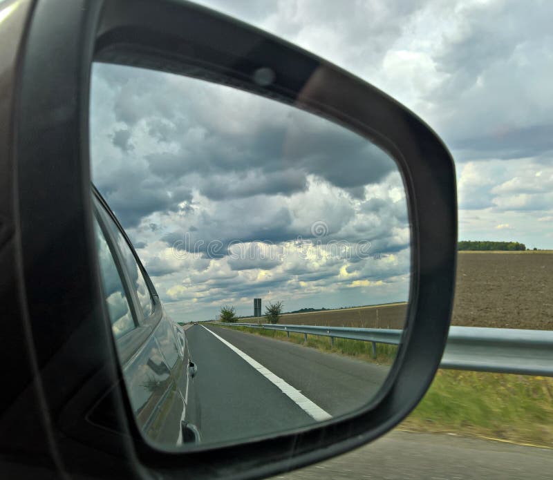 Rear View Mirror Reflecting Road and Cloudy Sky Stock Photo - Image of ...