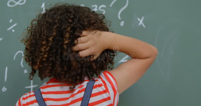 Rear View of Mixed-race Schoolgirl Scratching Her Head in Classroom at ...