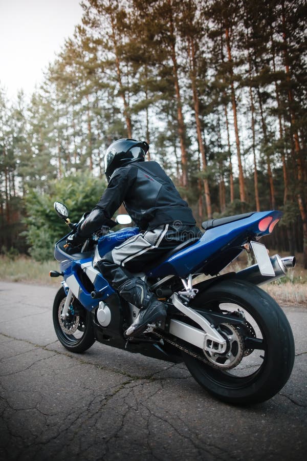 Rear View of Motorcycle Driver Driving in Helmet with Blurred Forest ...