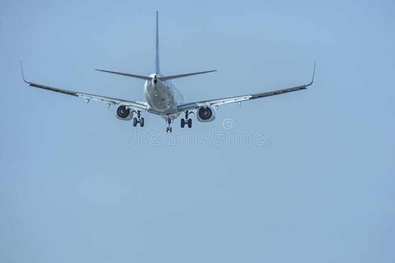 Rear View of a Passenger Jet with Landing Gear Deployed Approaching the ...