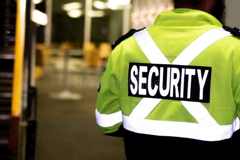 Rear View of a Person in a Neon Green Jacket with a Security Sign Stock ...