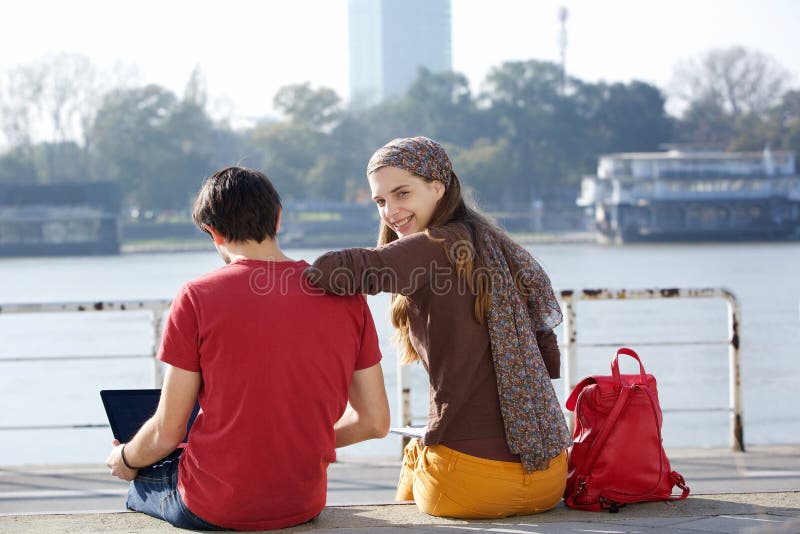 Two Students Working Together on Laptop Outdoors Stock Image - Image of ...