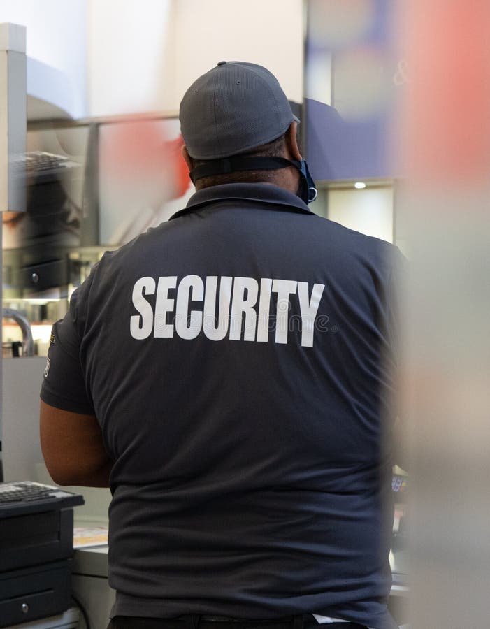 Rear View of a Security Guard in Uniform Patrolling in a Commercial ...