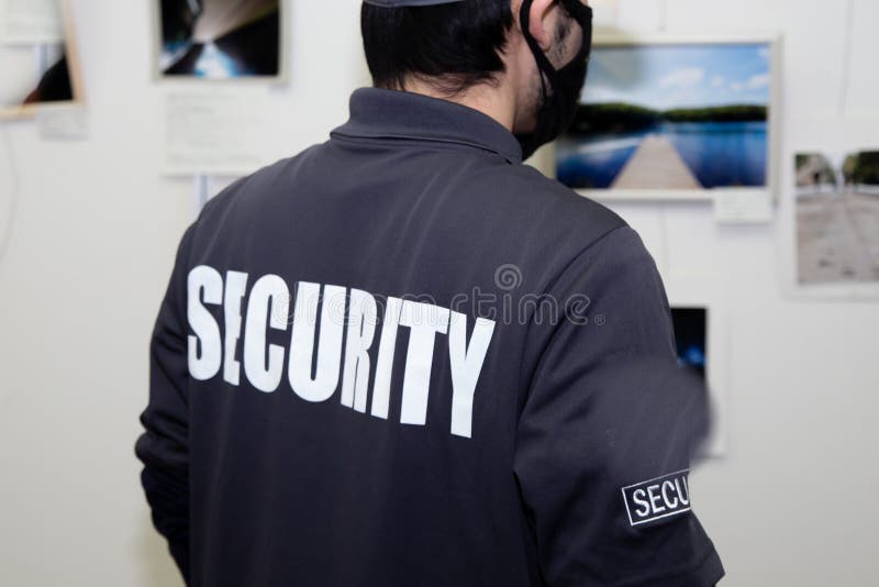 Rear View of a Security Guard in Uniform Patrolling in a Commercial ...