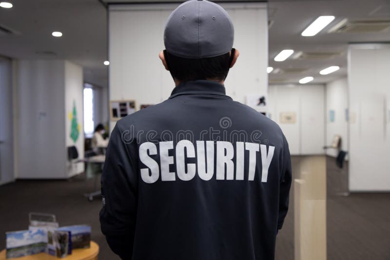 Rear View of a Security Guard in Uniform Patrolling in a Commercial ...