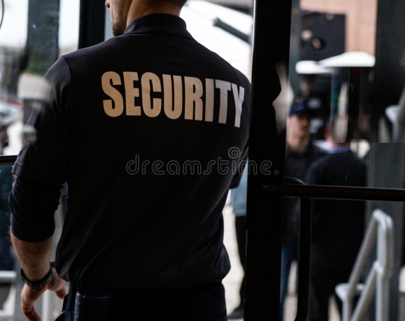 Rear View of a Security Guard in Uniform Patrolling in a Commercial ...