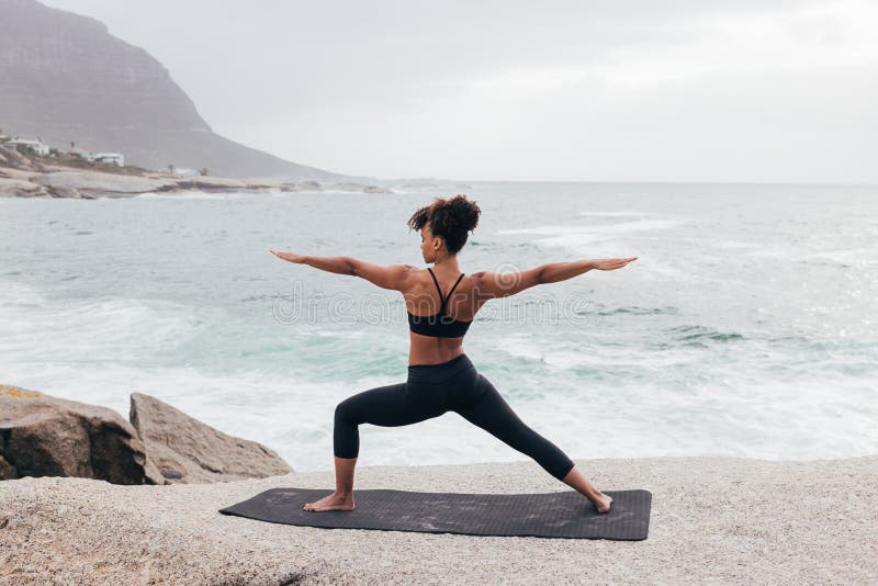 Rear View of Slim Female Practicing Warrior Pose by Ocean Stock Image ...