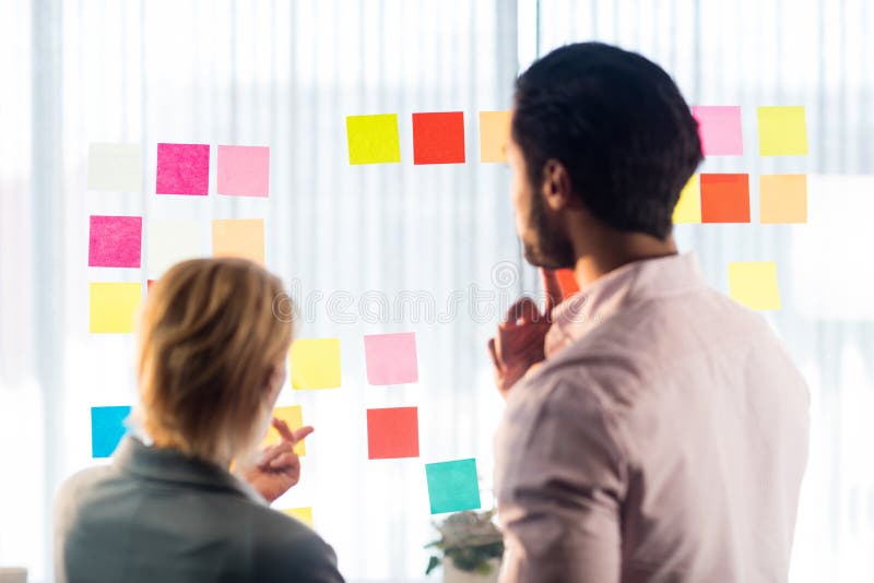 Rear View of Two Business People Looking at Post it Wall Stock Photo ...