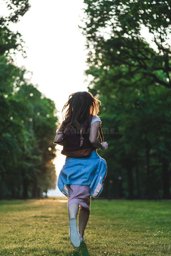 Rear View of Woman with Backpack Running on Meadow Stock Image - Image ...