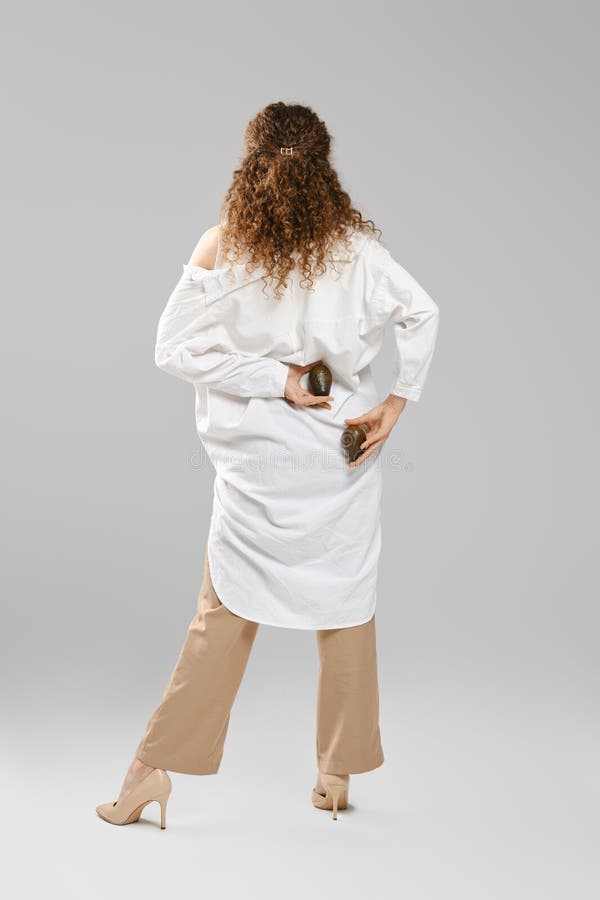 Rear View of Woman Holding Two Whole Avocado Behind Her Back Stock ...