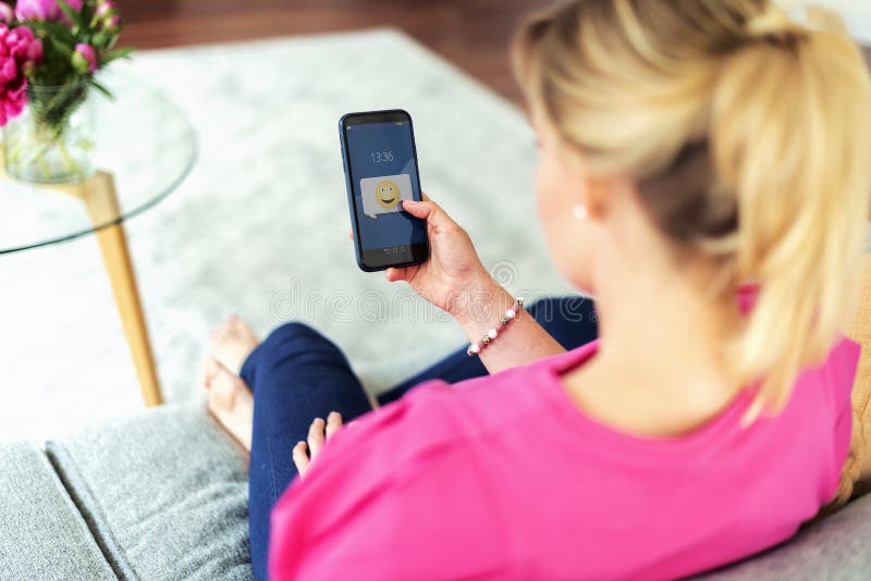 Rear View of a Woman Using Mobile Phone and Text Messaging at Home ...