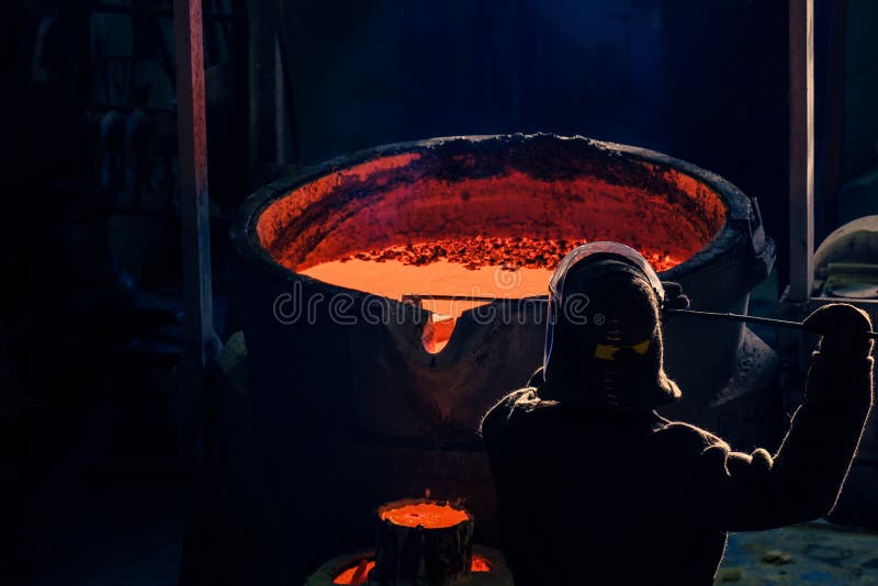 Foundry Worker in a Protective Mask Looks Inside the Vat in Which the ...