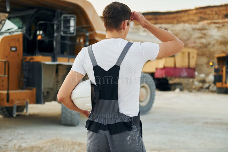 Rear View. Worker in Professional Uniform is on the Borrow Pit at ...