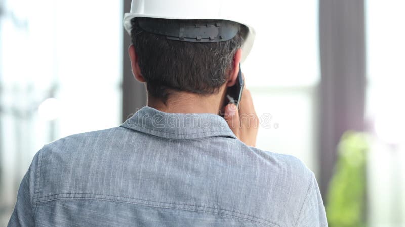 Rear View of Young Businessman Talking on Cell Phone at the Window ...