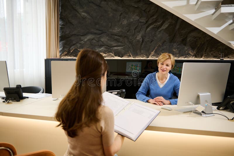 Rear View of a Young Female Client Consulting an Experienced Specialist ...