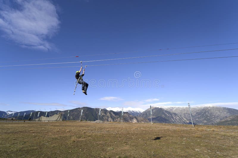 Rear View of Young Man Riding on Zip Line Against Blue Sky Stock Photo ...
