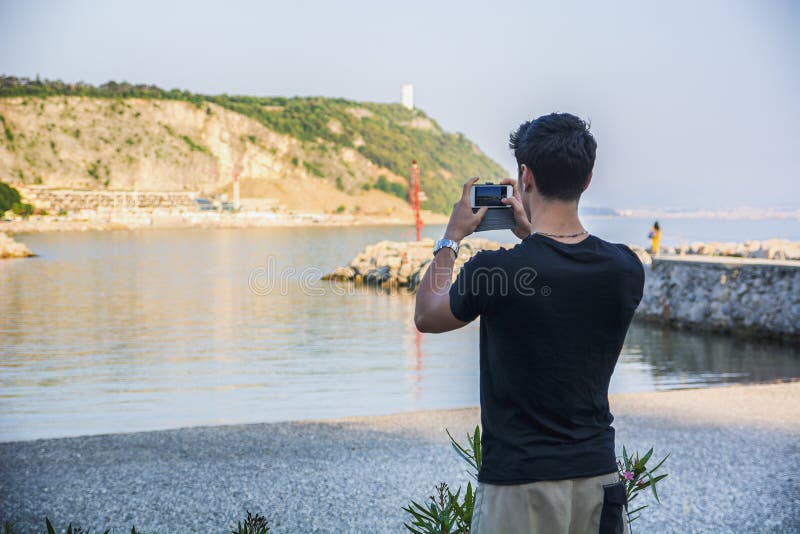 Rear View of Young Man Taking Photos at the Beach Stock Image - Image ...