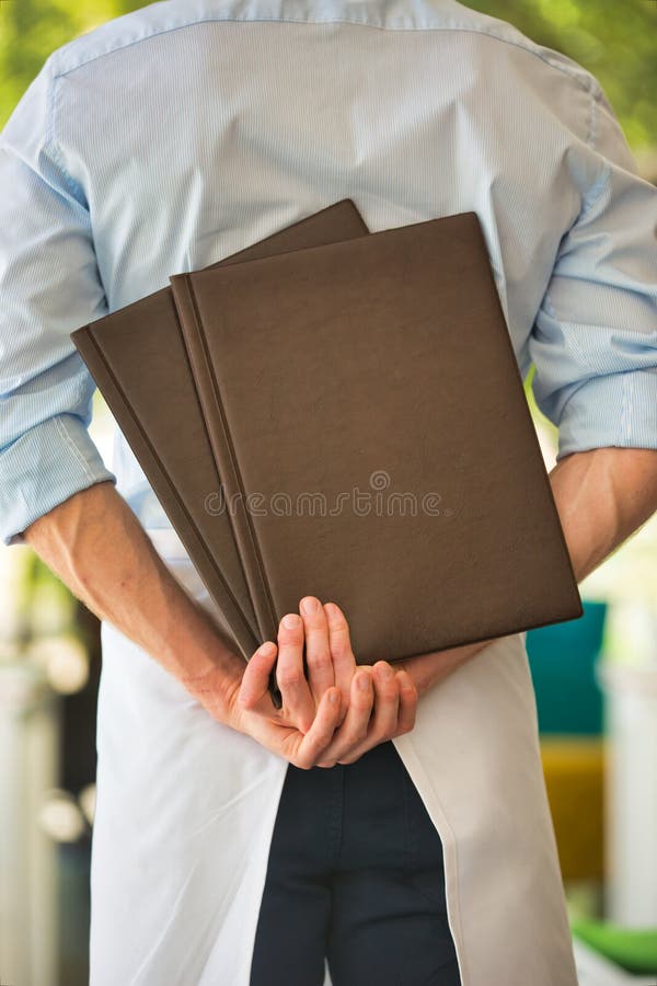 Rear View of Young Waiter Holding Menus while Standing at Restaurant ...