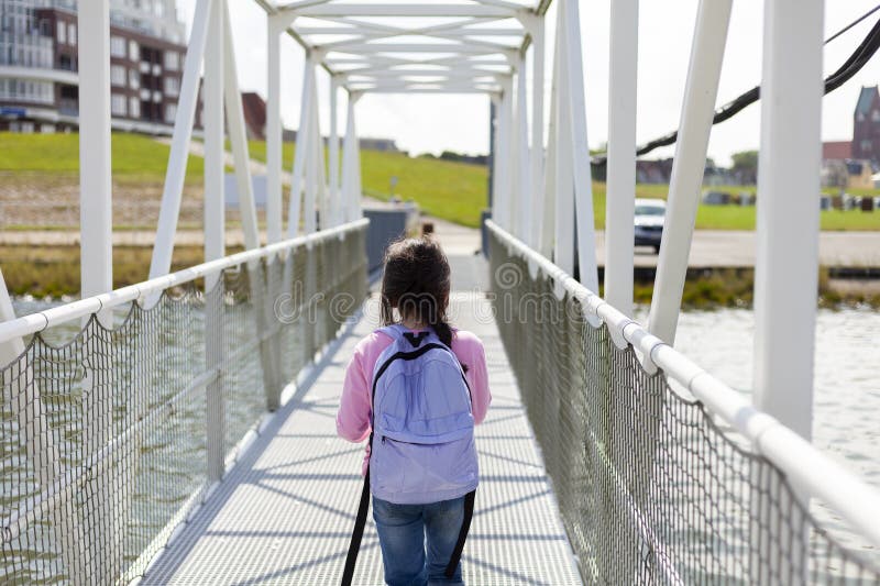 Rear View of a Young Woman Walking on a Bridge Over a River Stock Image ...
