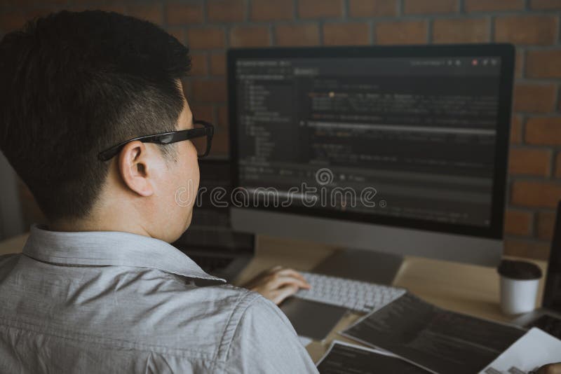 Software Developer Holds The Pen Pointing To The Computer Screen And Is Analyzing The Code Stock