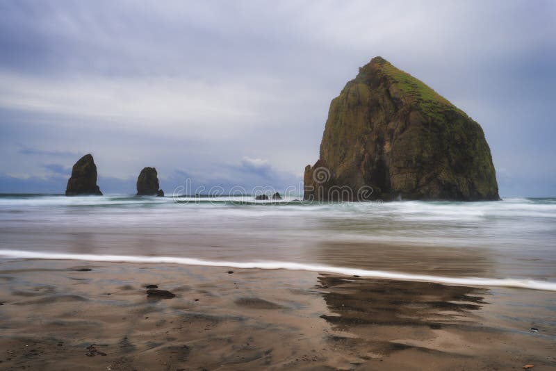 Cannon Beach Haystack Rock and Needles Under Cloudy Skies Stock Image ...