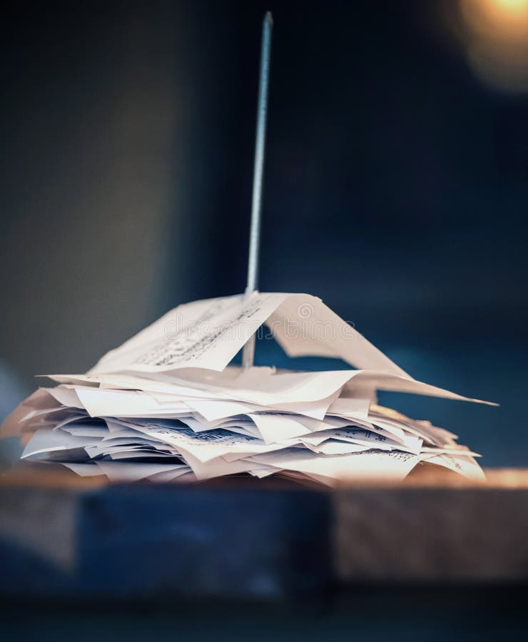 Stack of Receipts Piled Up on a Wooden Table at a Bustling Cafe during ...