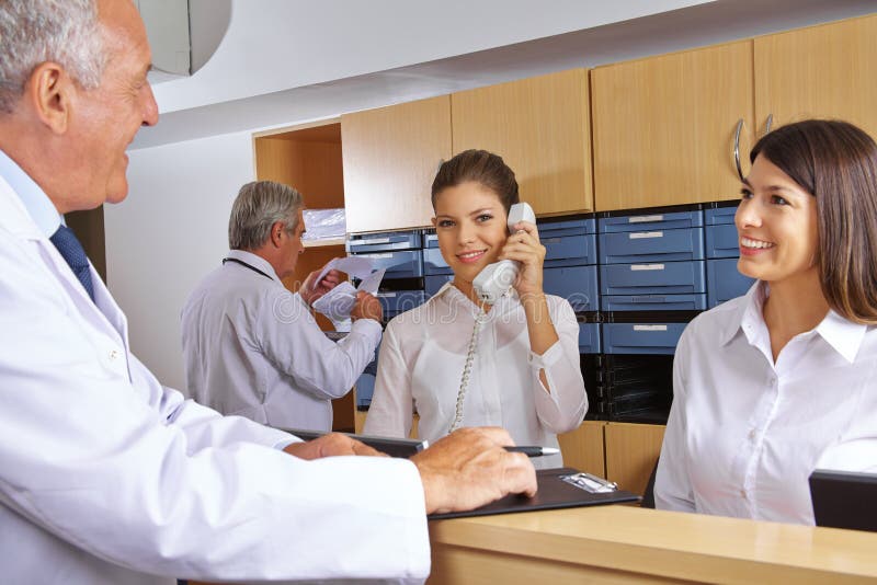 Recepción Ocupada En Un Hospital Con Los Doctores Y Los Recepcionistas ...